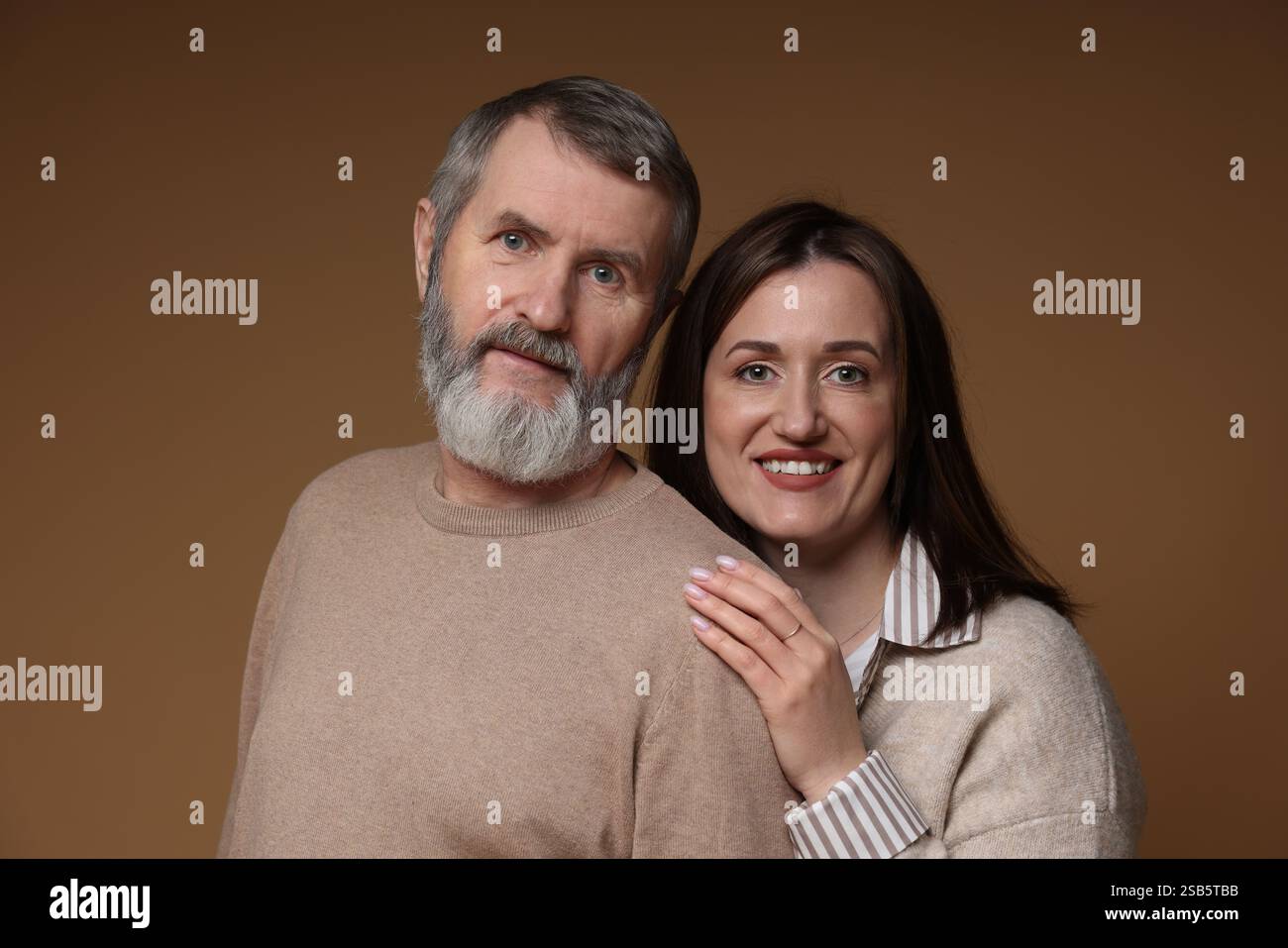 Family portrait of happy daughter and her father on brown background ...