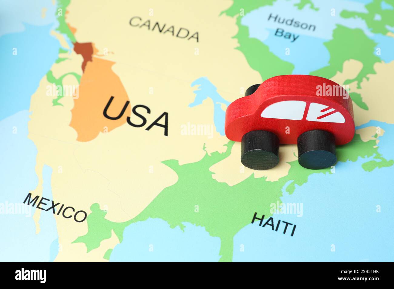 Red wooden toy car on world map. Road trip Stock Photo - Alamy