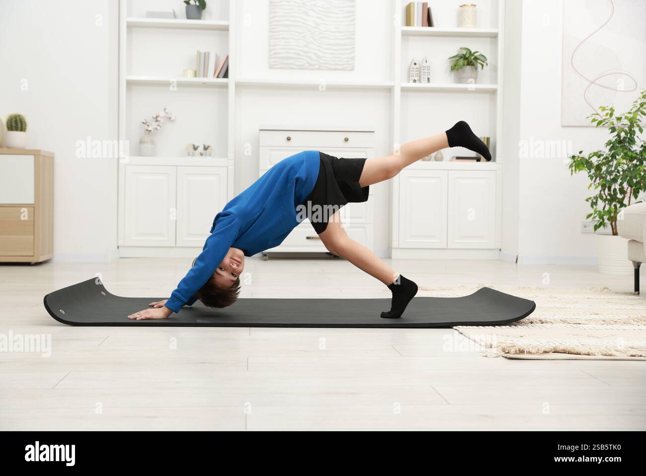 Boy doing exercise on fitness mat at home. Sport activity Stock Photo ...