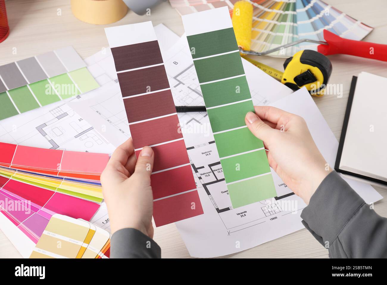 Designer with color selection chart working on house project at table ...