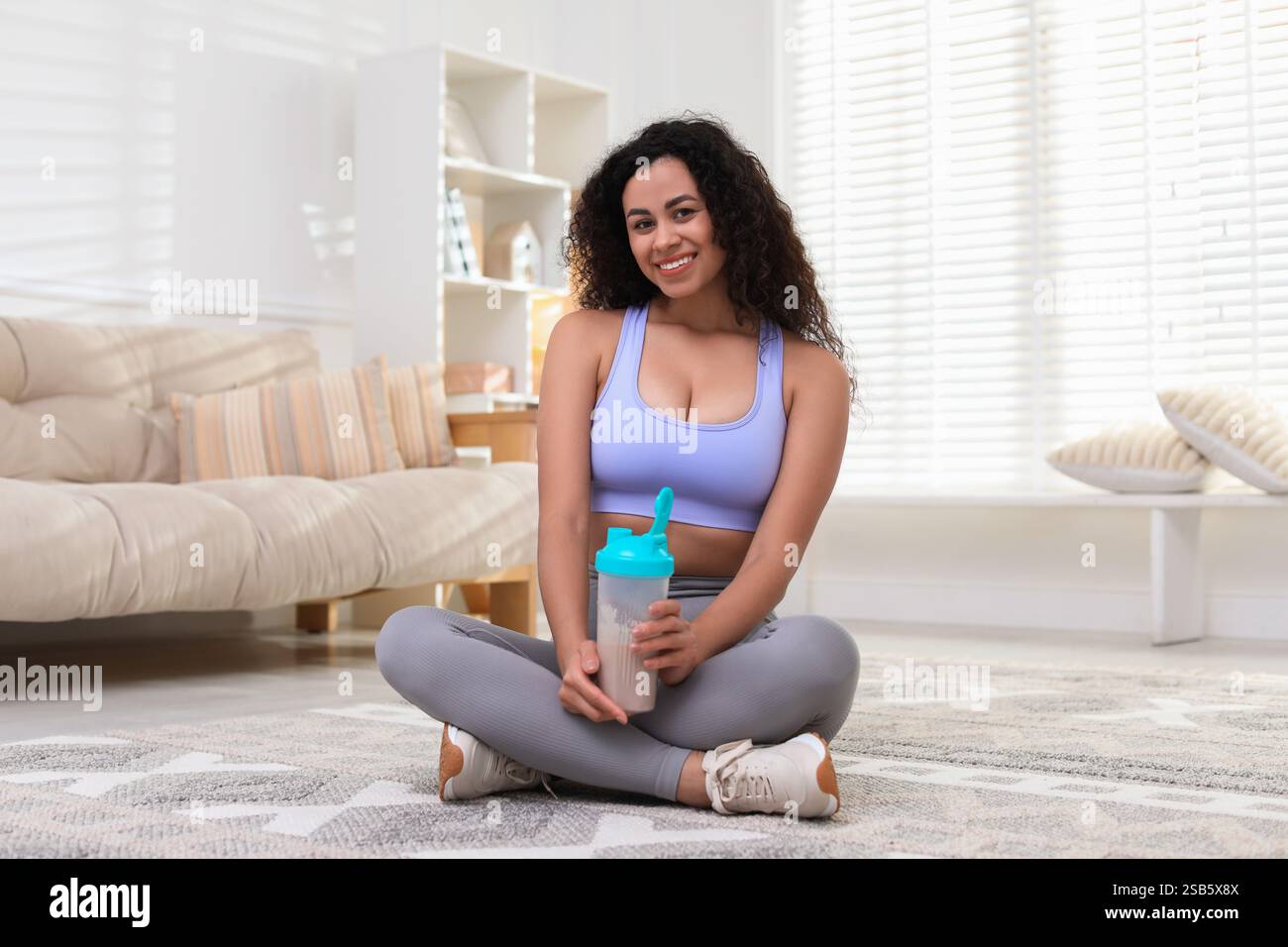 Beautiful woman with protein shake at home Stock Photo - Alamy