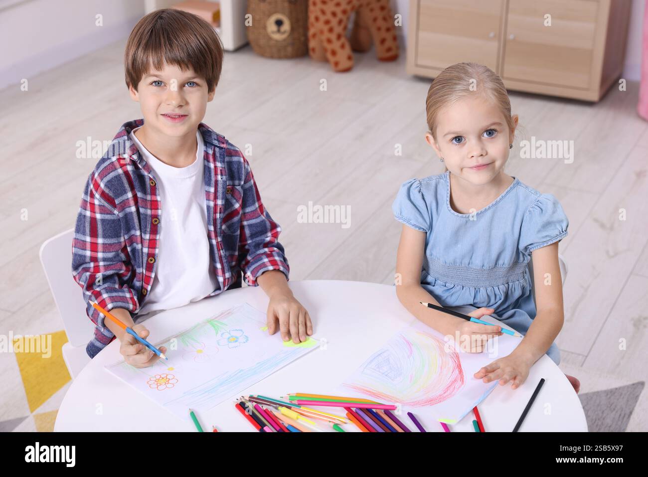Cute children drawing at white table in kindergarten Stock Photo - Alamy