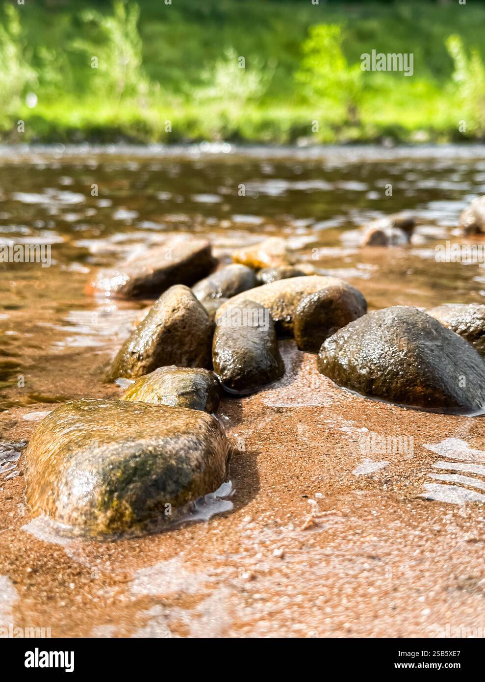 Rocky shoreline with a body of water in the background. The rocks are ...