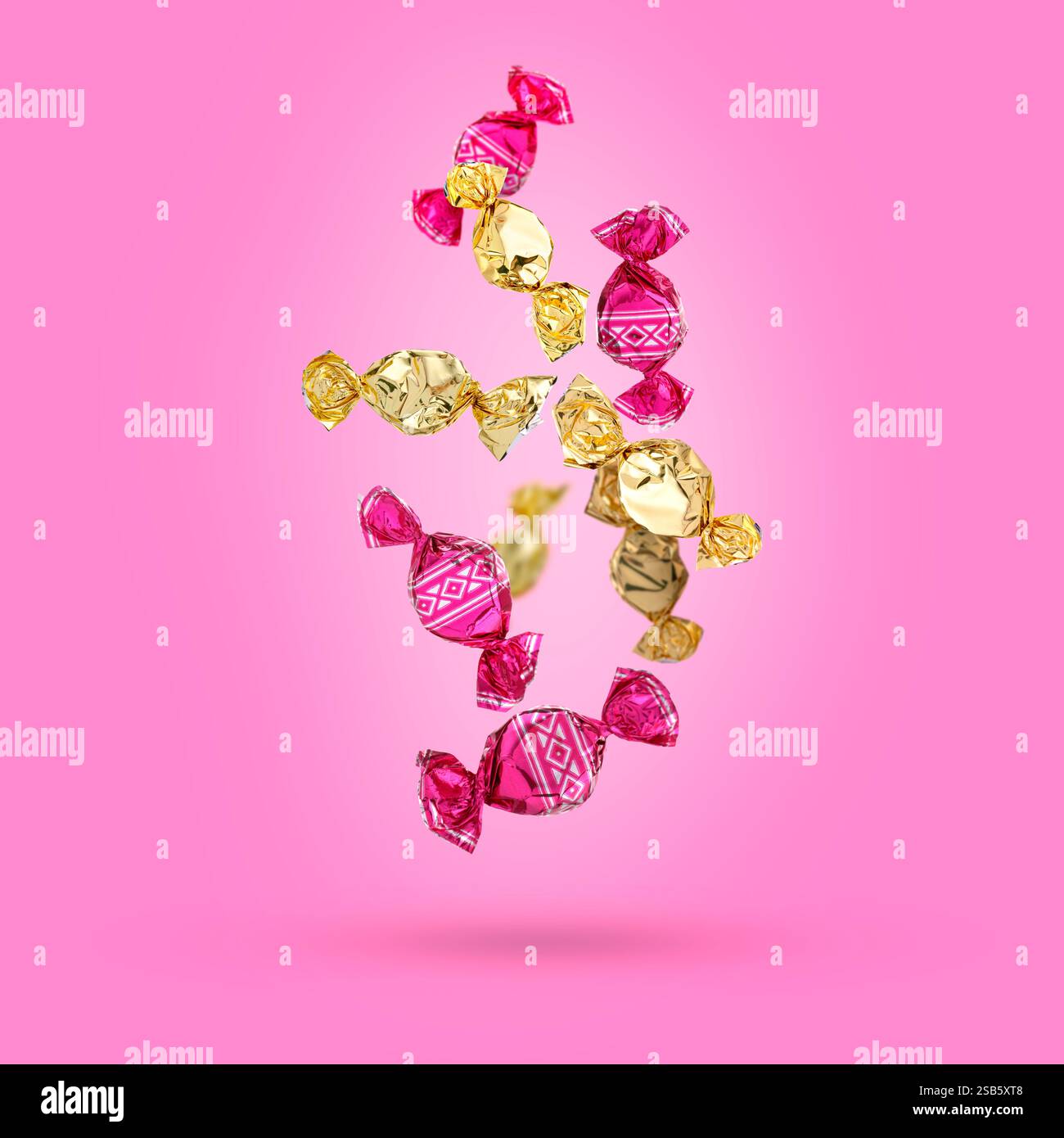 Candies in bright wrappers falling on pink background Stock Photo - Alamy