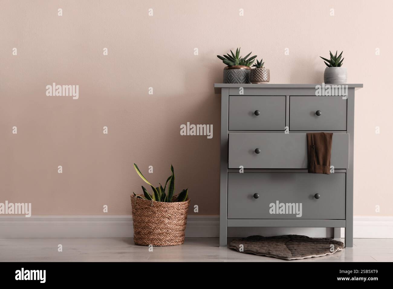Chest of drawers and decor indoors. Wall in shade of mocha mousse ...