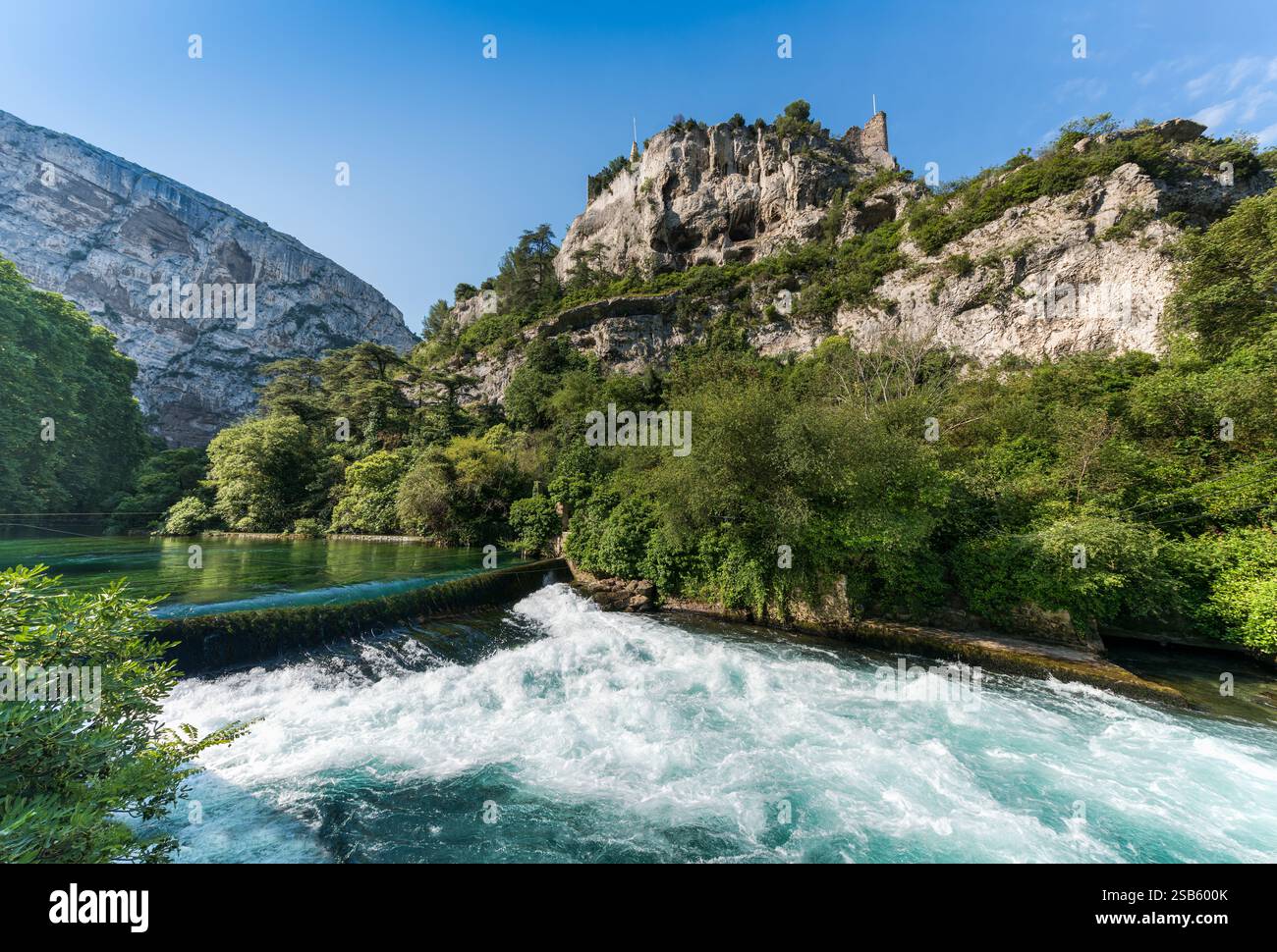 The river Sorgue in Fontaine de Vaucluse in the background the castle ...