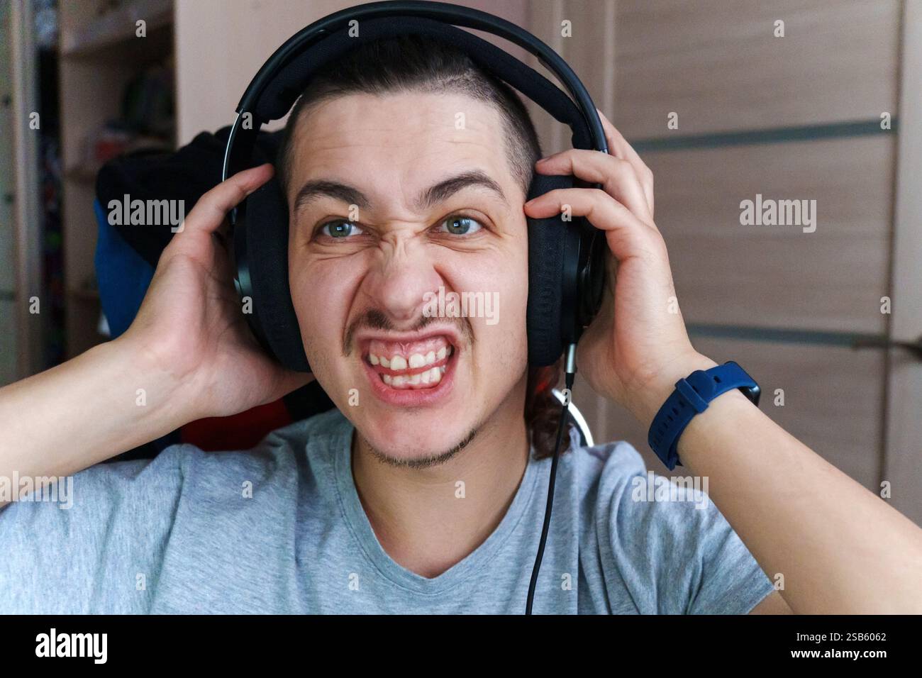 With headphones snugly in place, a young man expresses excitement and ...