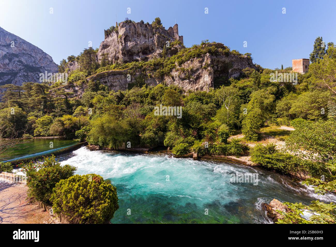 The river Sorgue in Fontaine de Vaucluse in the background the castle ...