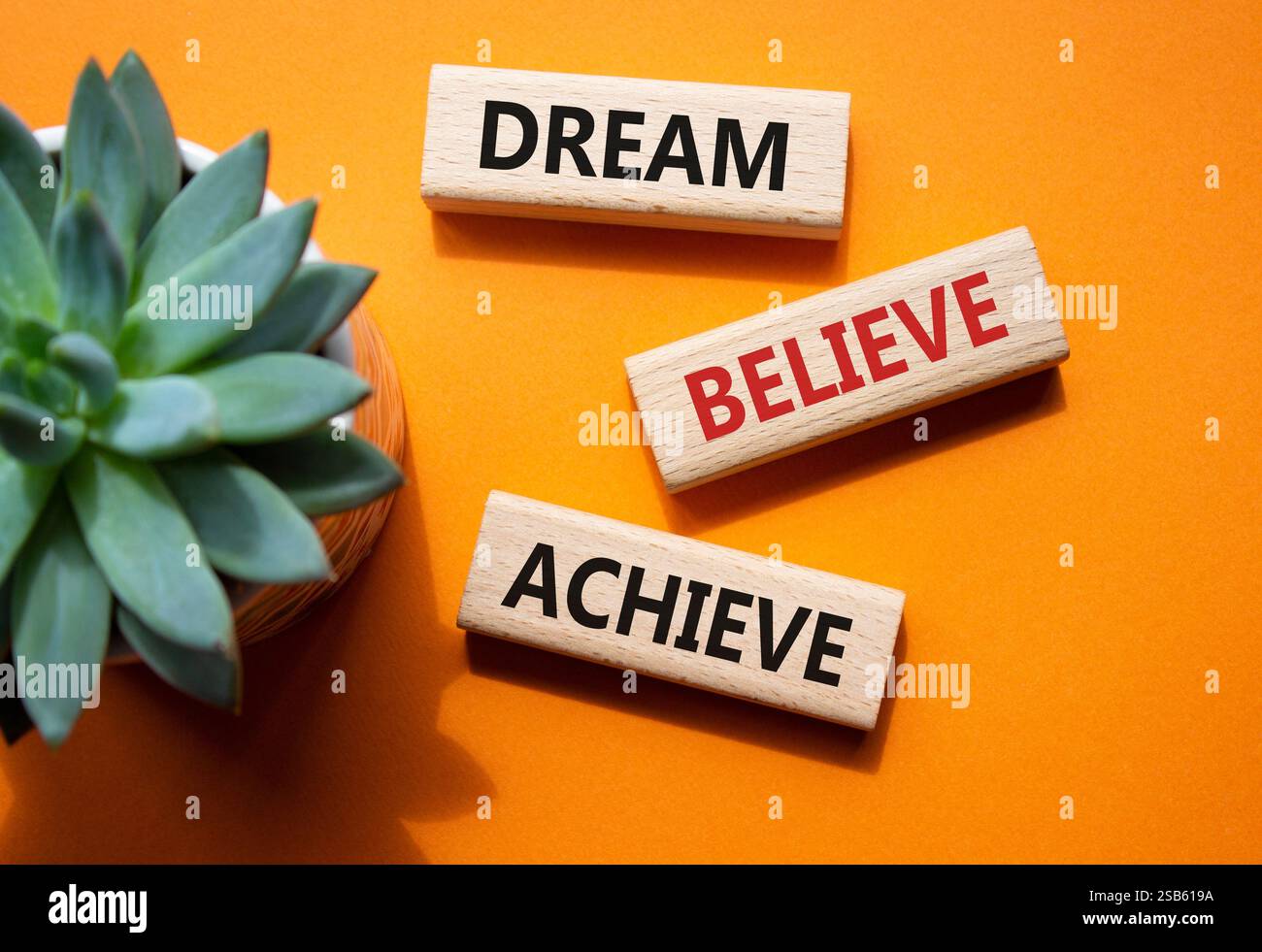 Dream Believe Achieve symbol. Wooden blocks with words Dream Believe ...