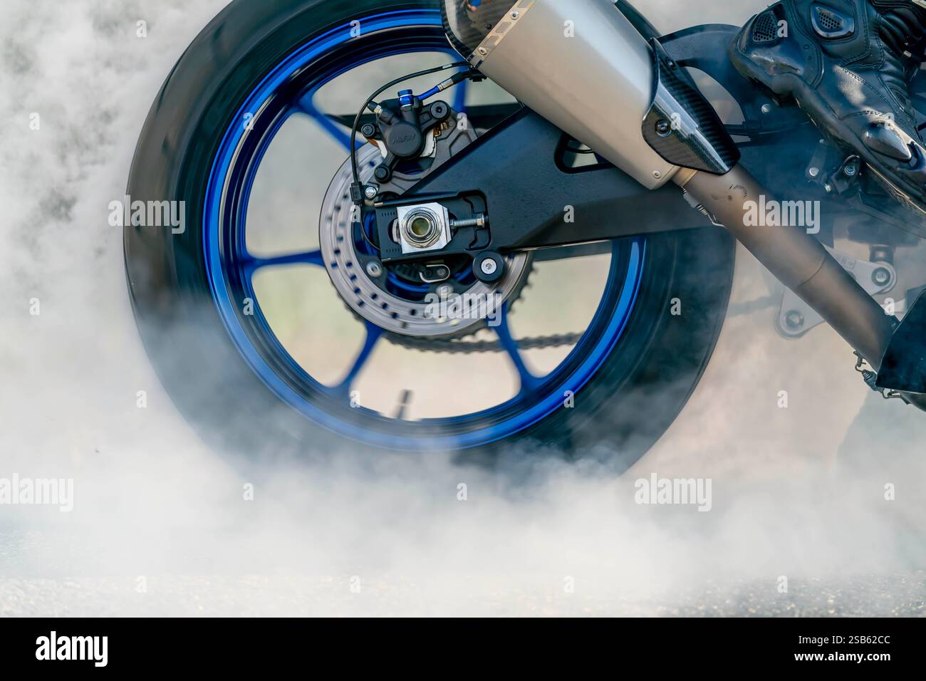 A motorcyclist revs past the red line, gripping the handlebars as the ...
