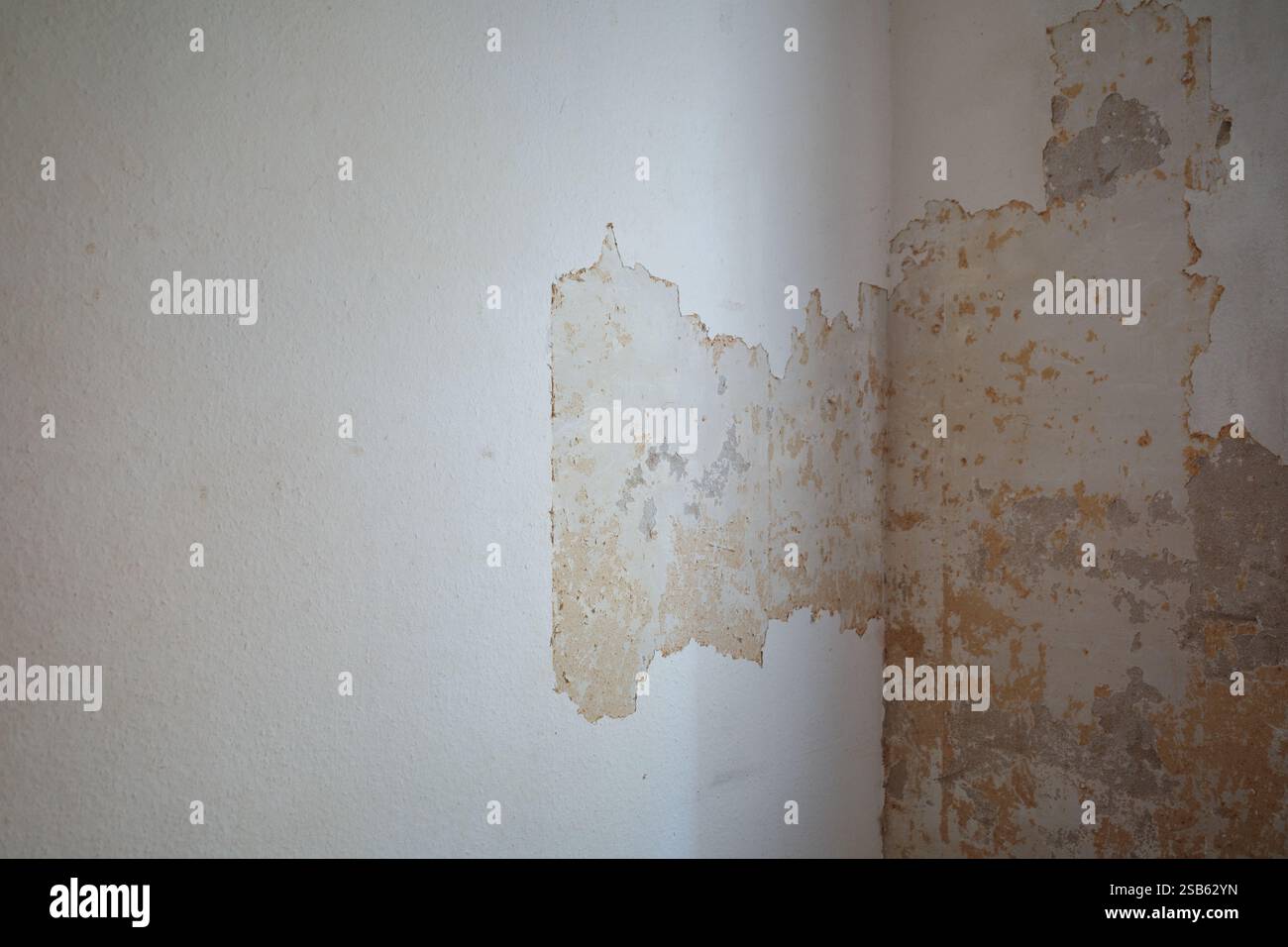 A close-up view of a deteriorating wall with peeling paint and exposed ...