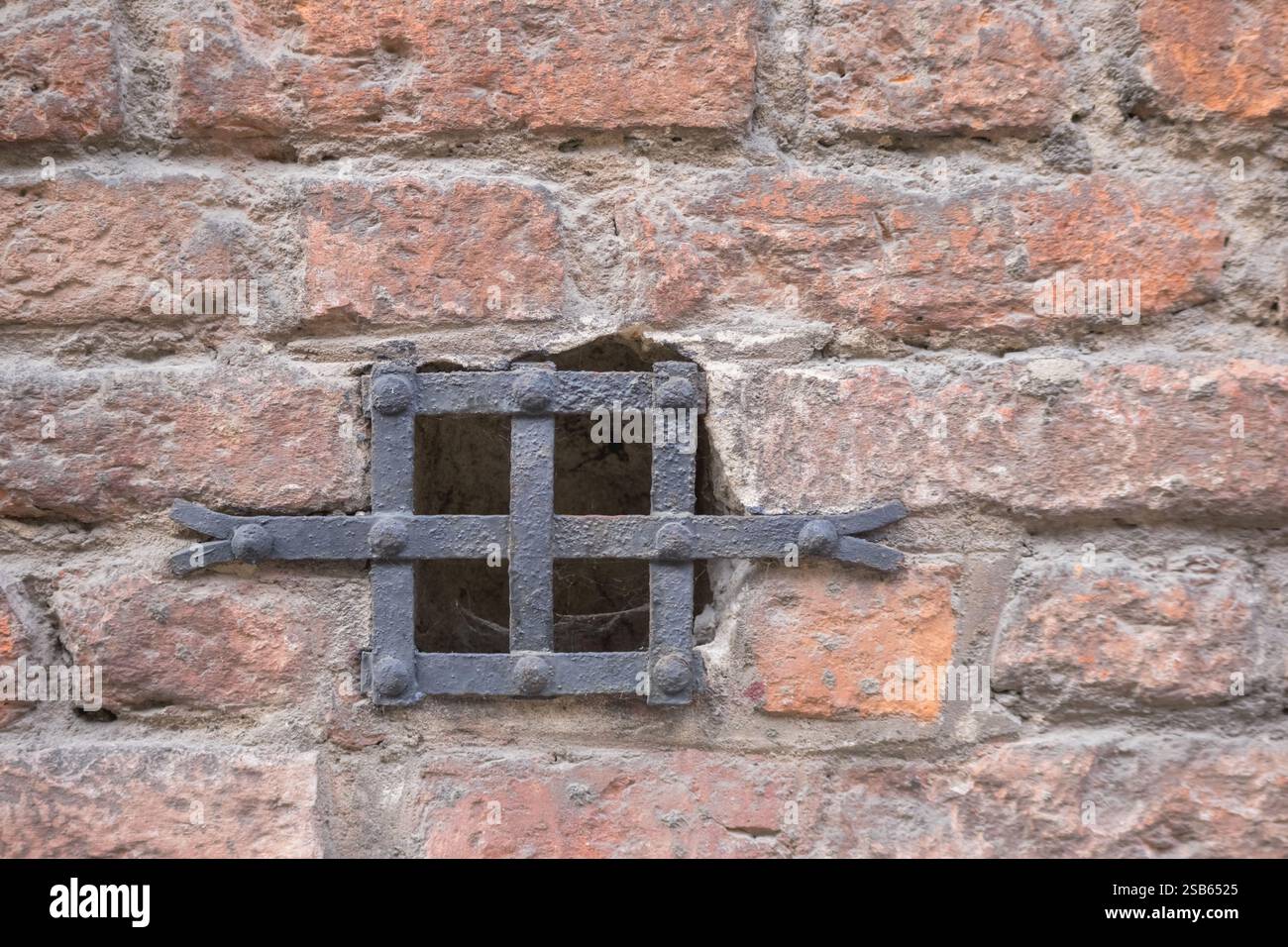 a small metal grid attached to a brick wall Stock Photo - Alamy