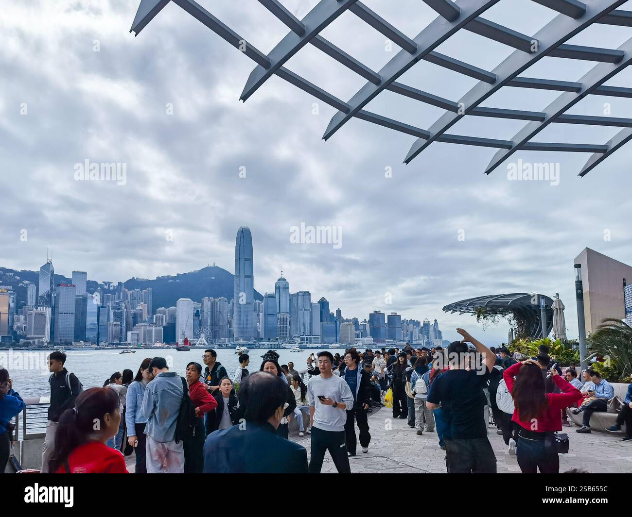 Hong Kong, China - February 01, 2025 : A bustling crowd enjoys the Tsim Sha Tsui Promenade ...