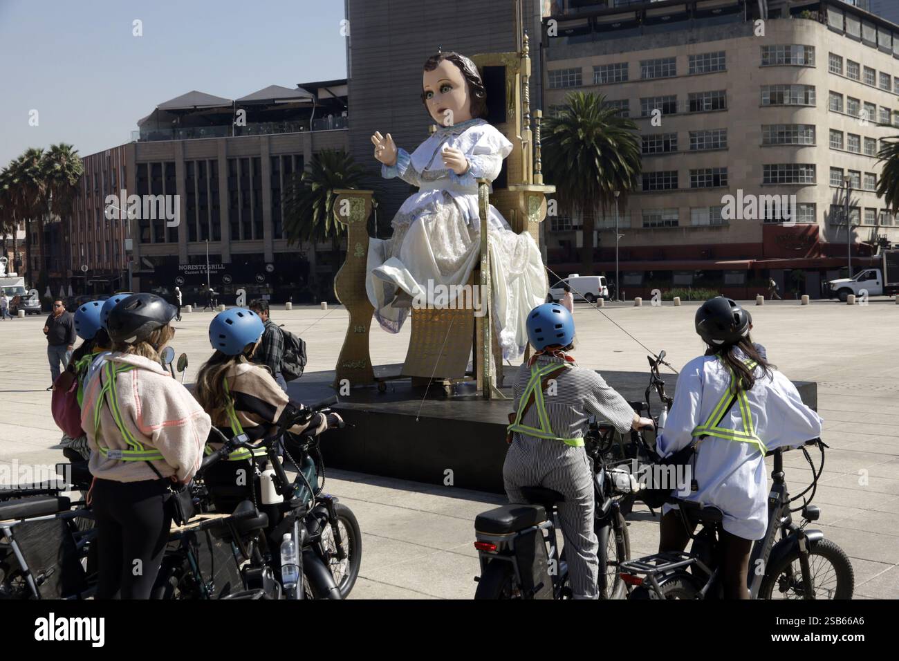 Non Exclusive: Cyclists look the Monumental Baby Jesus Doll installed at the first Tamale Fair ...