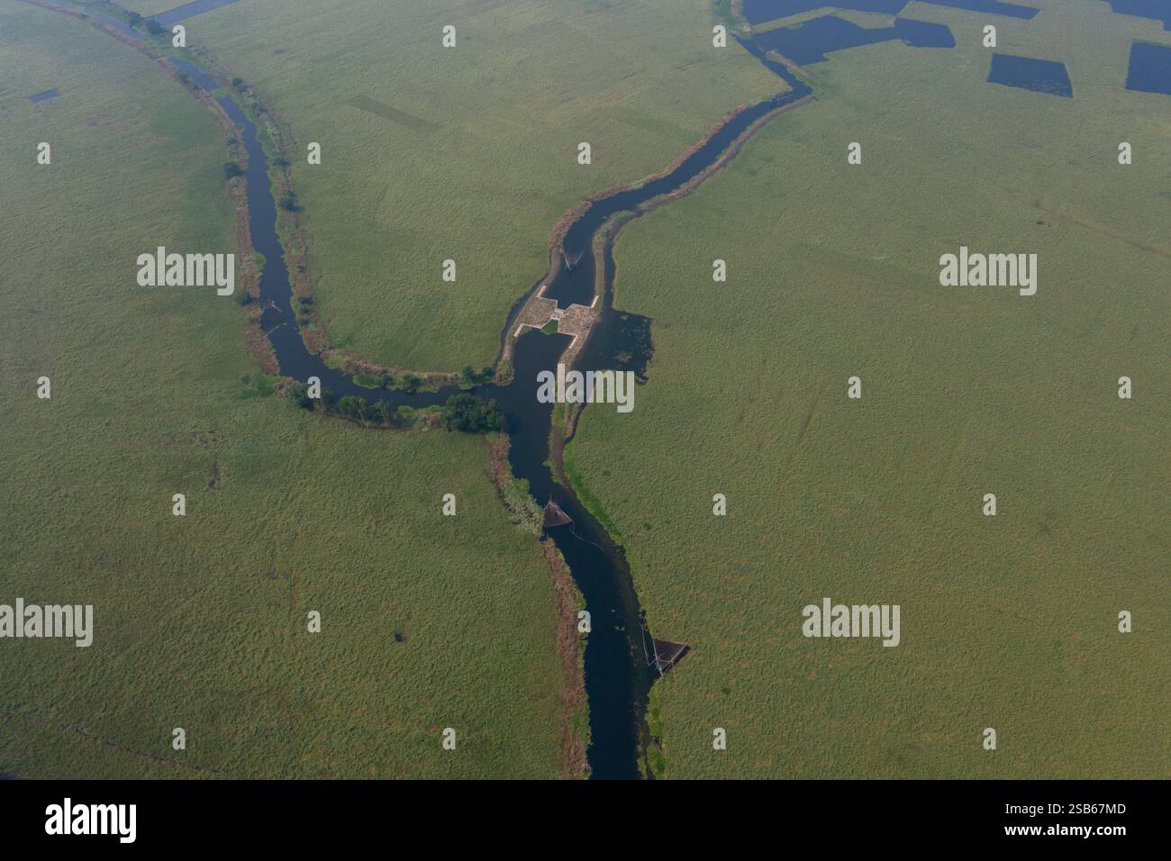 Aerial view of a vast marsh dotted with traditional fishing traps in ...