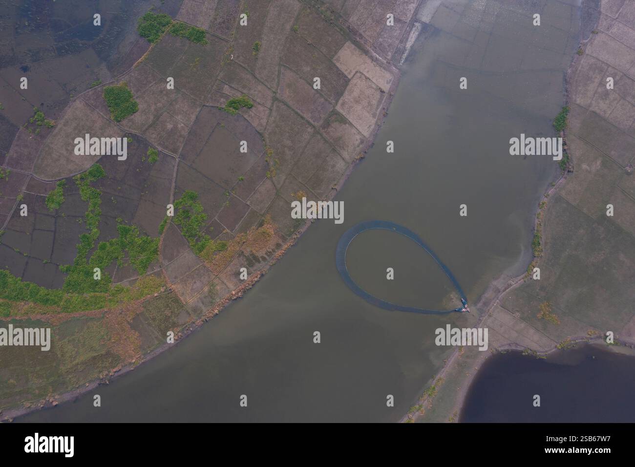 Aerial view of fishermen casting a giant fishing net in the Brahmaputra ...