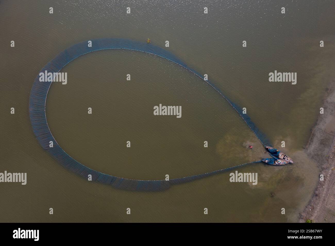 Aerial view of fishermen casting a giant fishing net in the Brahmaputra ...
