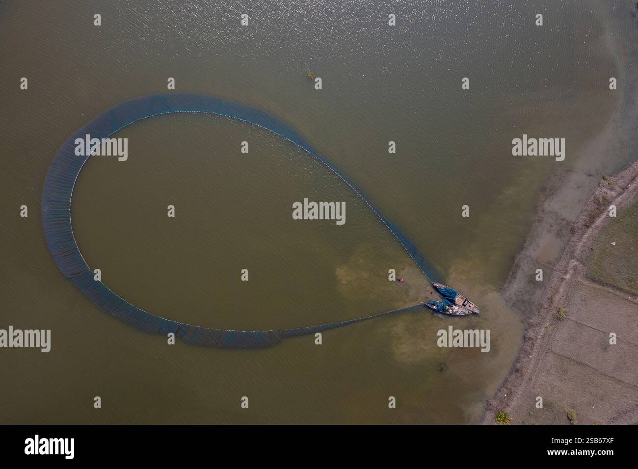 Aerial view of fishermen casting a giant fishing net in the Brahmaputra ...