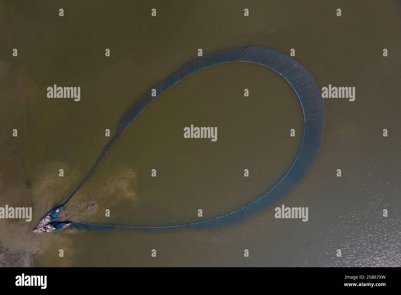 Aerial view of fishermen casting a giant fishing net in the Brahmaputra ...