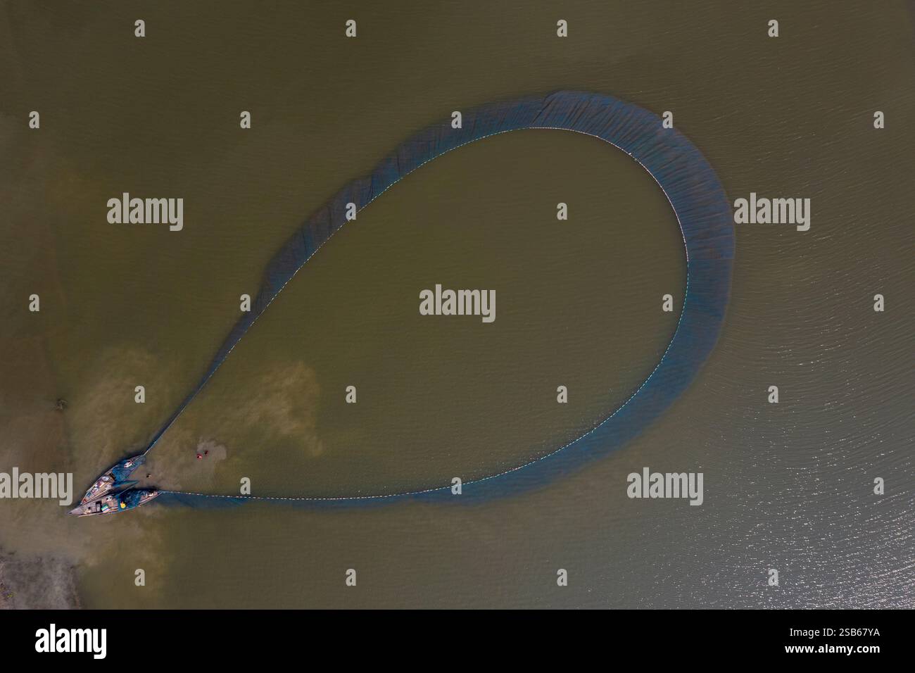 Aerial view of fishermen casting a giant fishing net in the Brahmaputra ...