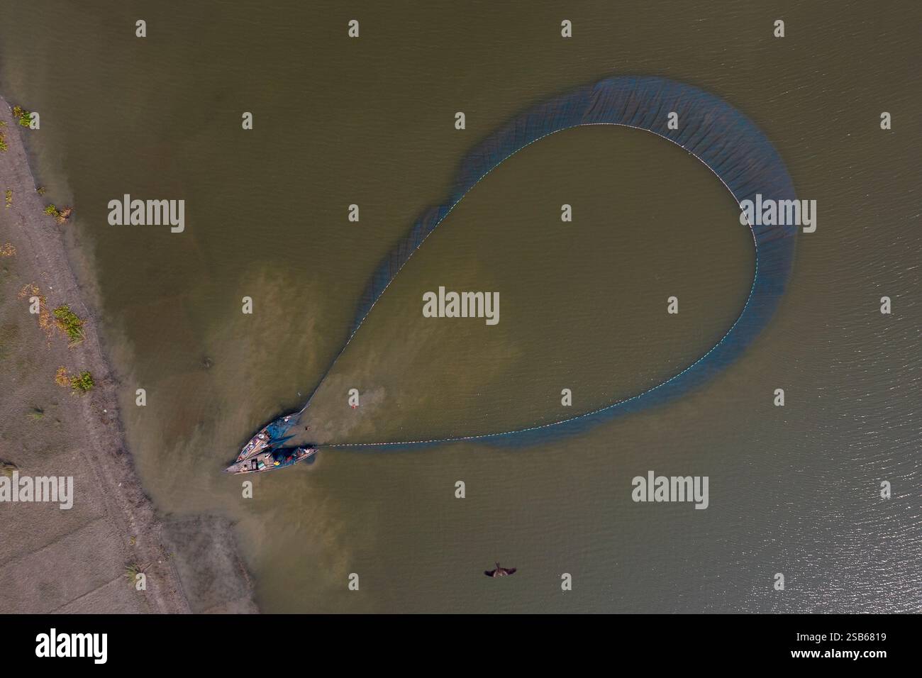 Aerial view of fishermen casting a giant fishing net in the Brahmaputra ...