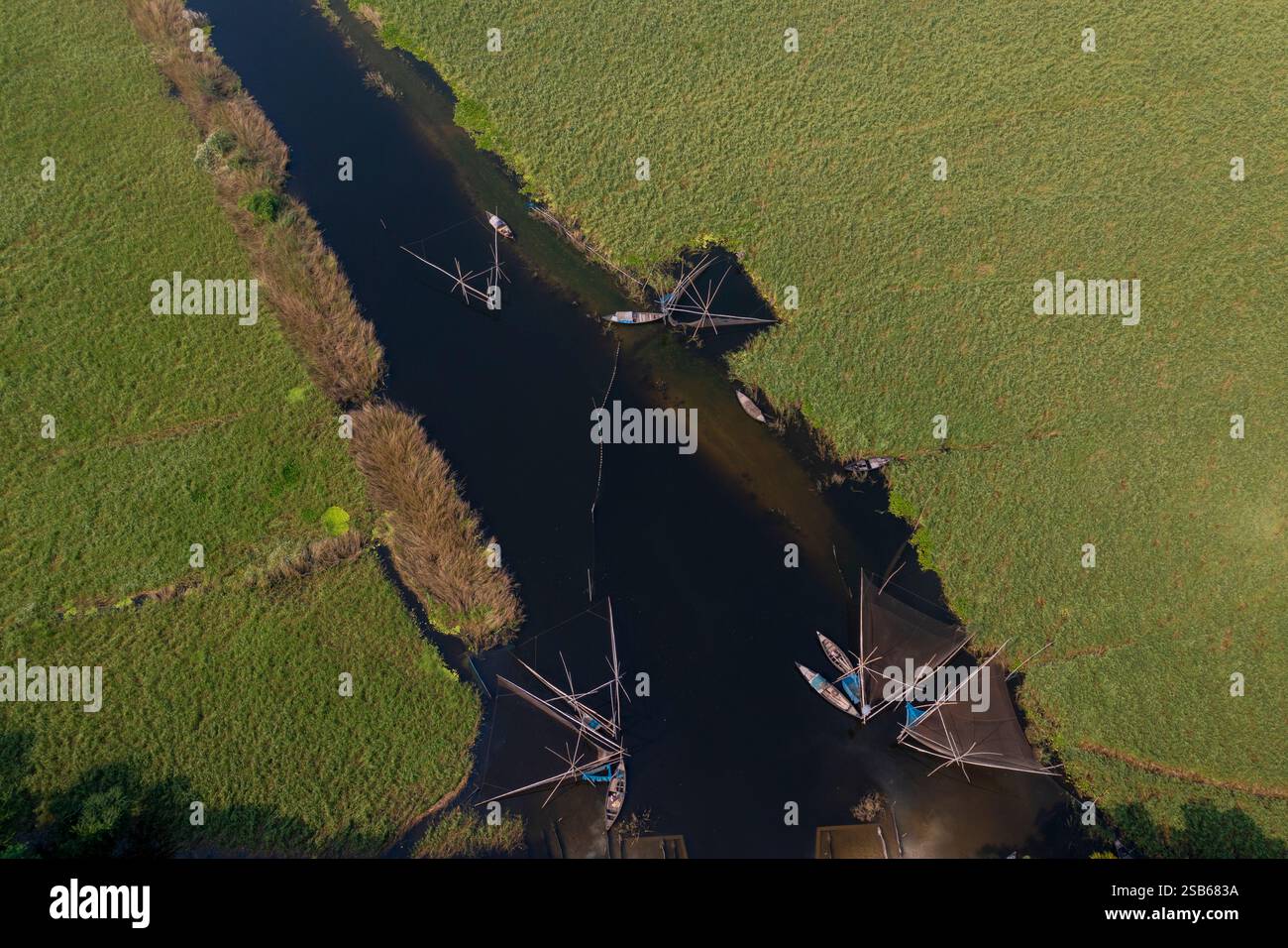Aerial view of a vast marsh dotted with traditional fishing traps in ...