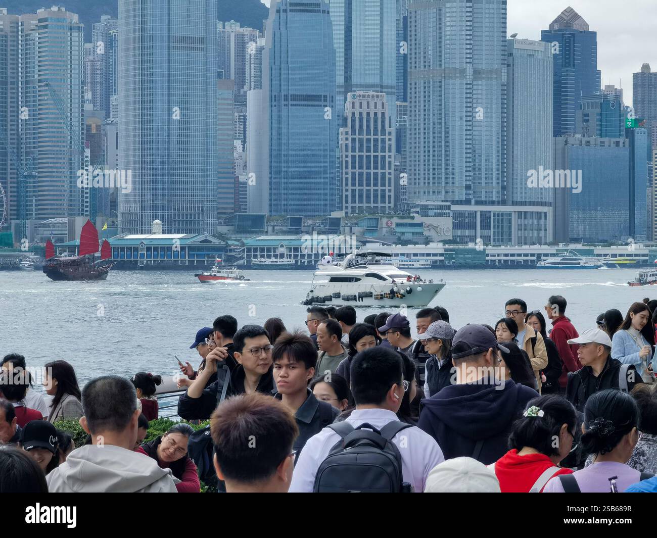 Hong Kong, China - February 01, 2025 : A bustling crowd enjoys the Tsim Sha Tsui Promenade ...