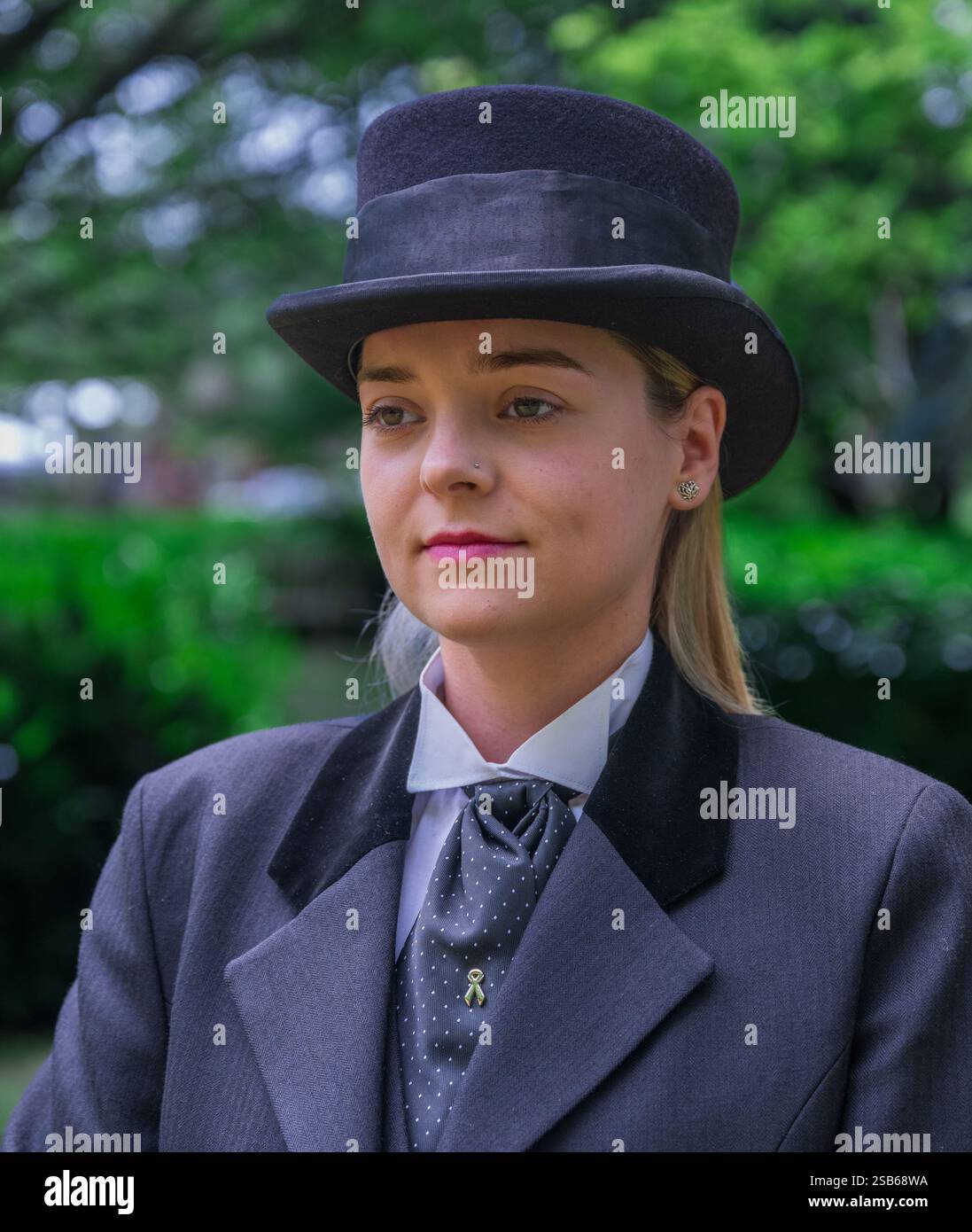 A young pretty lady funeral director in traditional attire with top hat ...