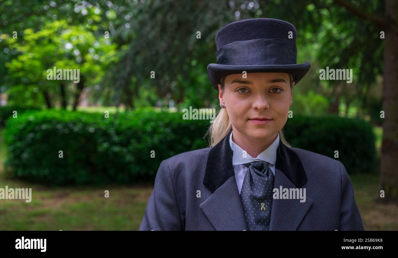 A young pretty lady funeral director in traditional attire with top hat ...