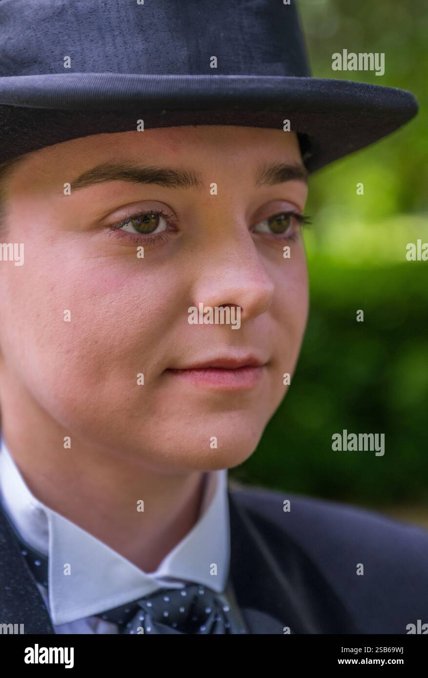 A young pretty lady funeral director in traditional attire with top hat ...
