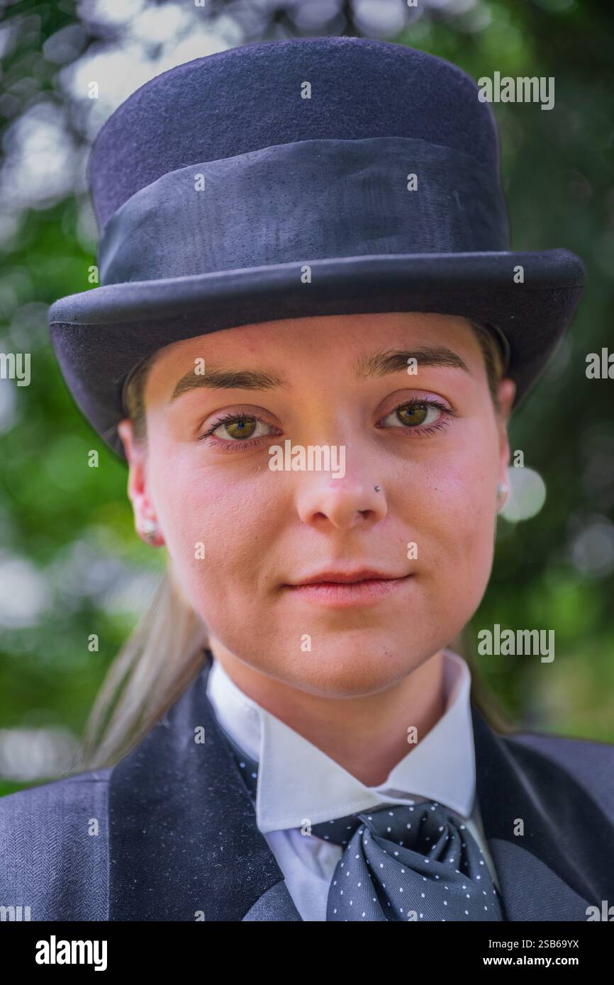 A young pretty lady funeral director in traditional attire with top hat ...