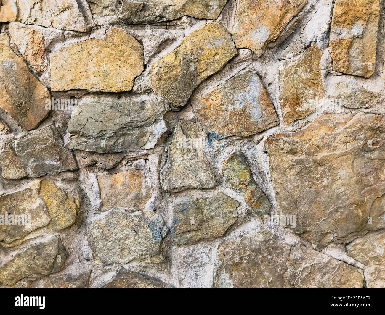 Wall made of stone with a few blue spots on it. The wall is brown and ...