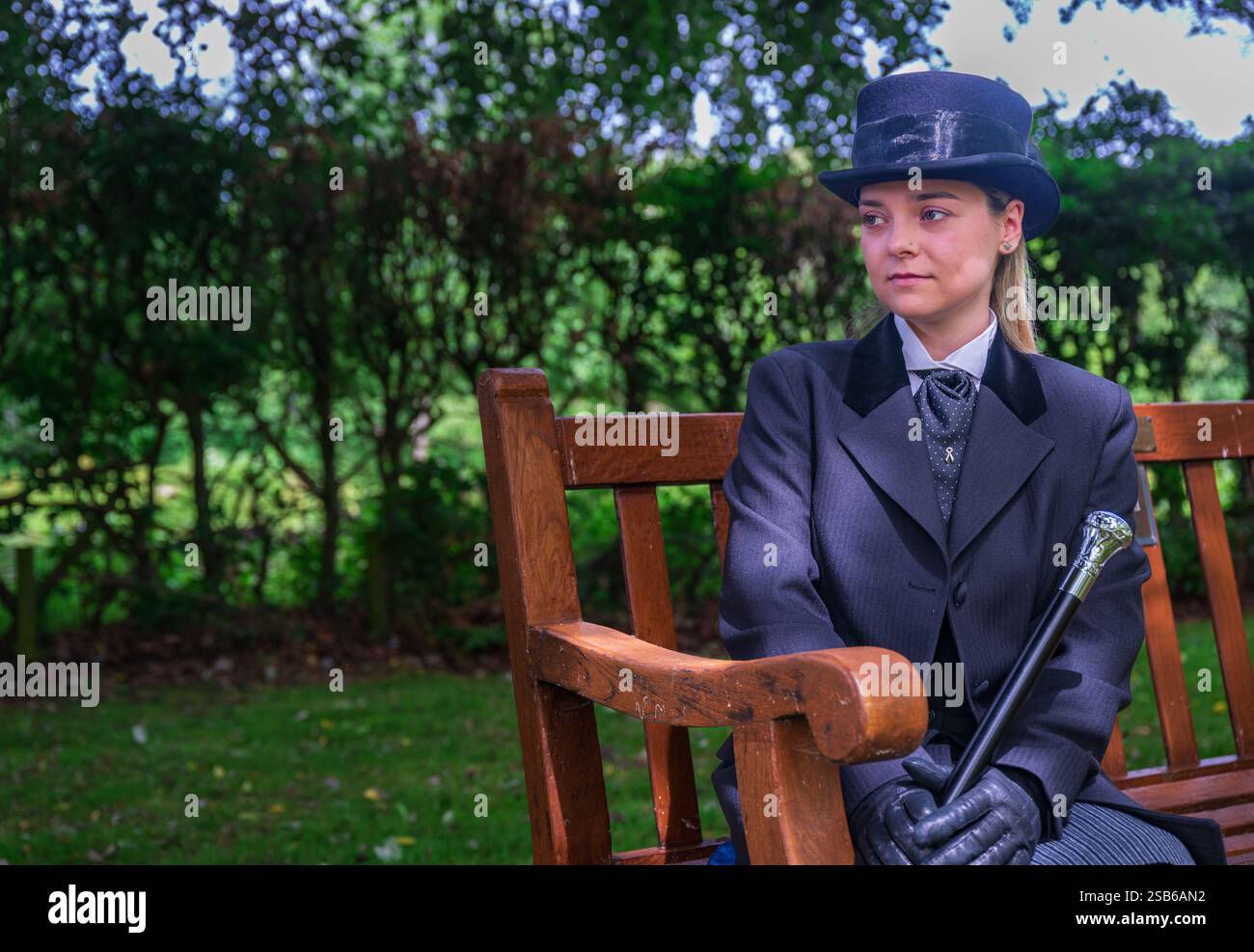 A young pretty lady funeral director in traditional attire with top hat ...