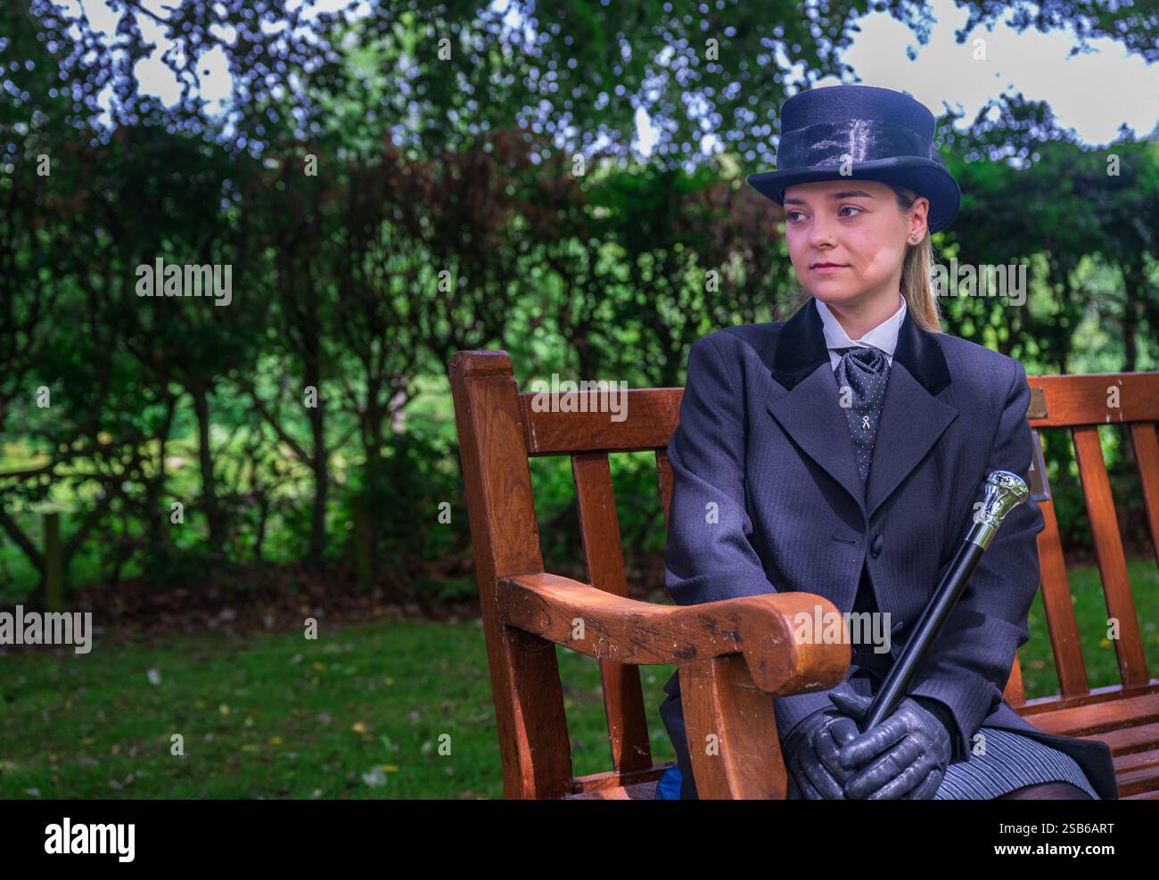 A young pretty lady funeral director in traditional attire with top hat ...