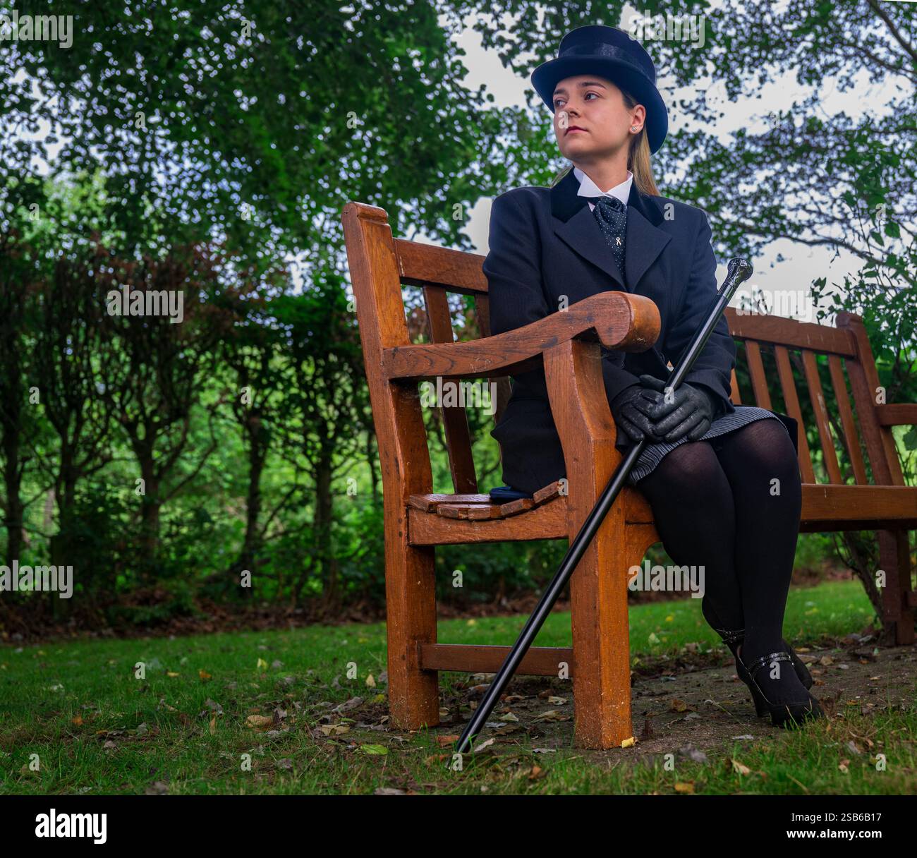 A young pretty lady funeral director in traditional attire with top hat ...
