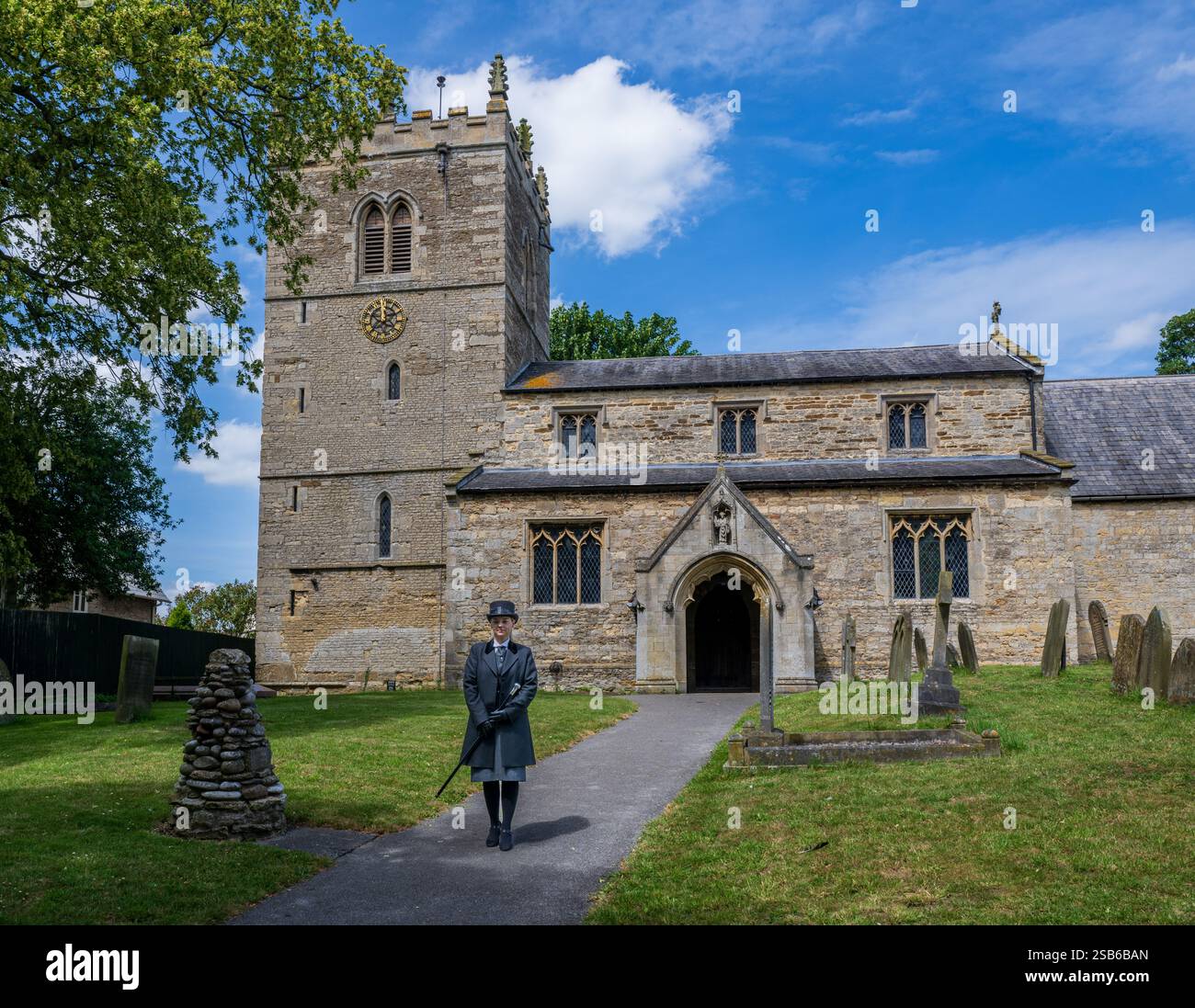 A young pretty lady funeral director in traditional attire with top hat ...