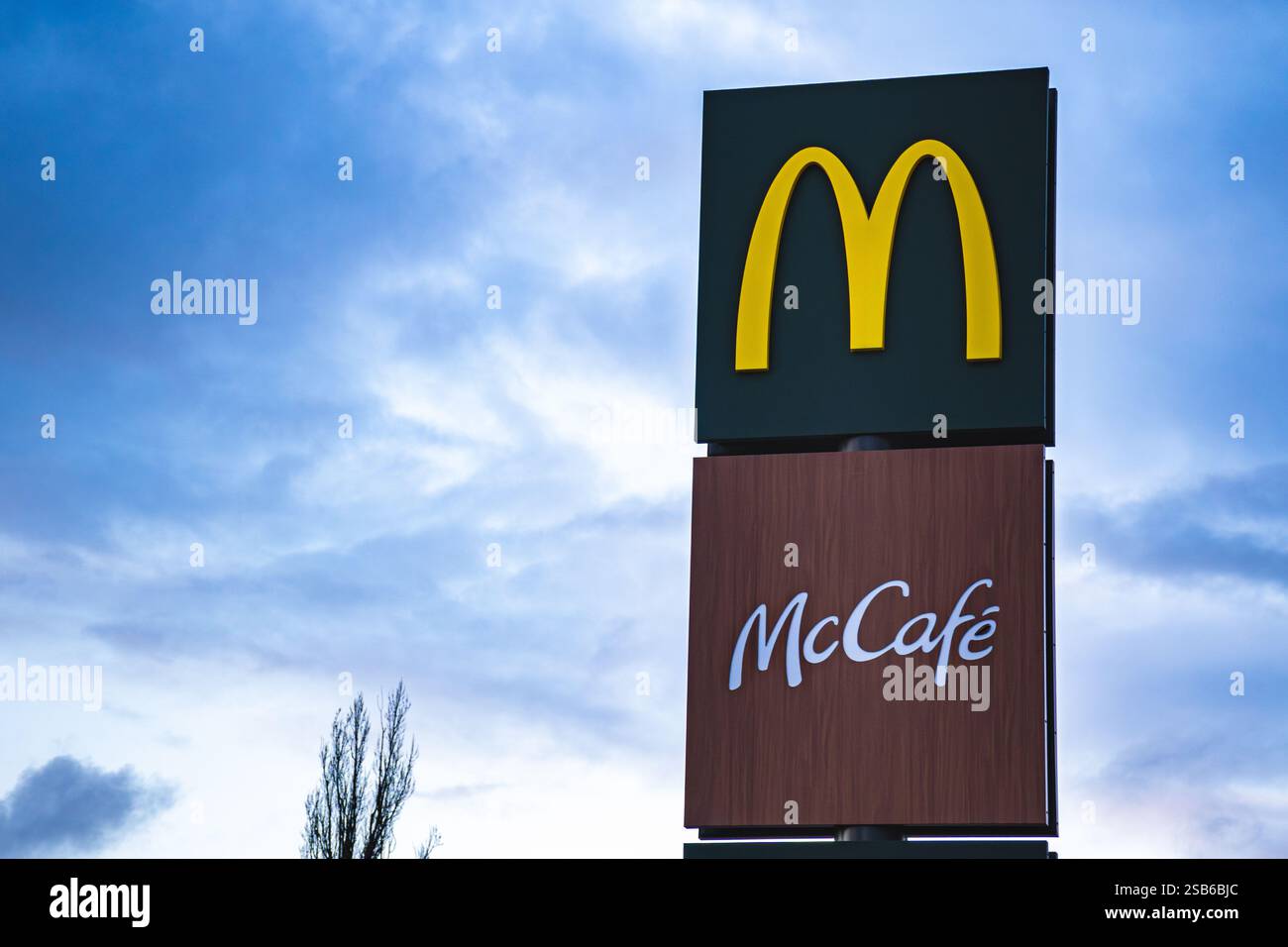 A prominent fast food restaurant sign stands tall outdoors, illuminated ...