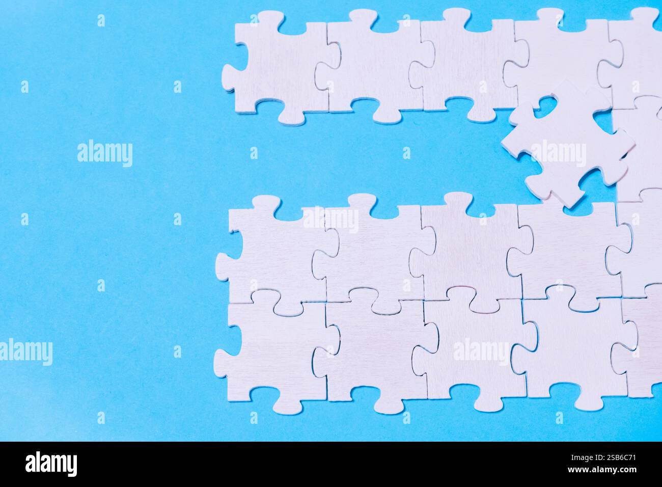 Puzzle is shown with a blue background. The puzzle pieces are white and ...