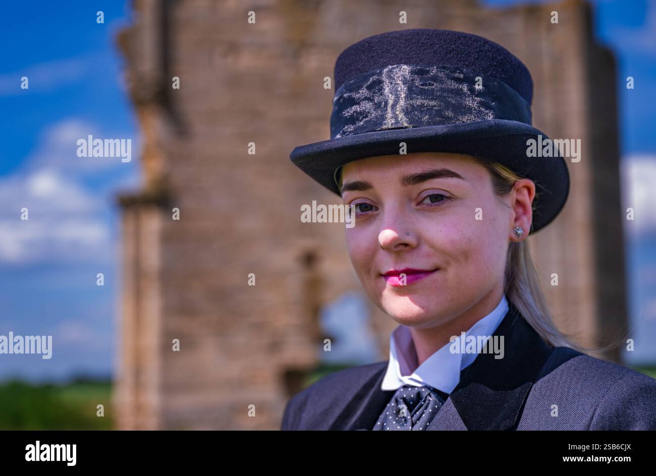 A young pretty lady funeral director in traditional attire with top hat ...