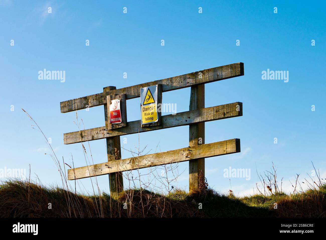 isolated Wooden fence with warning signs against falling from steep ...