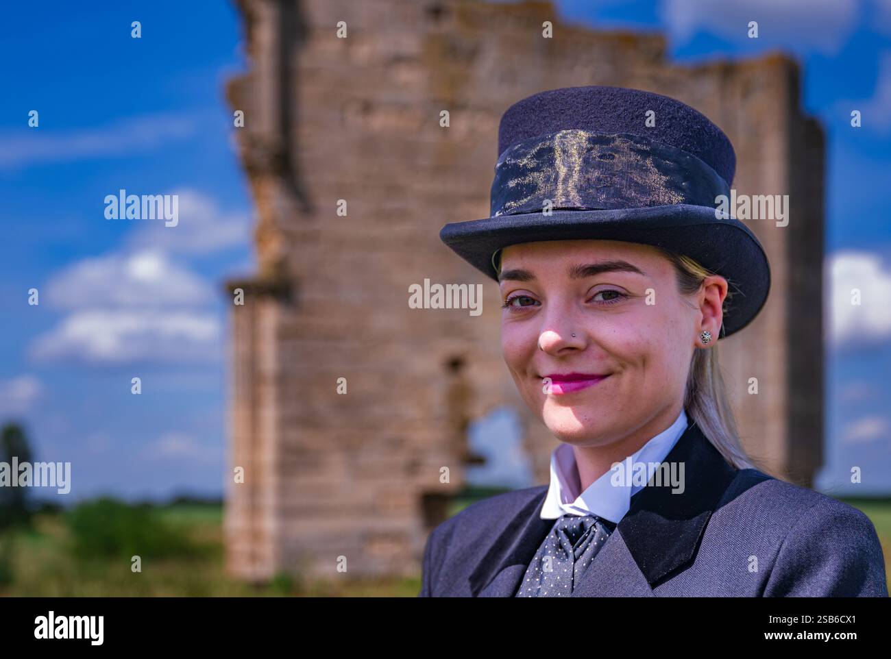 A young pretty lady funeral director in traditional attire with top hat ...