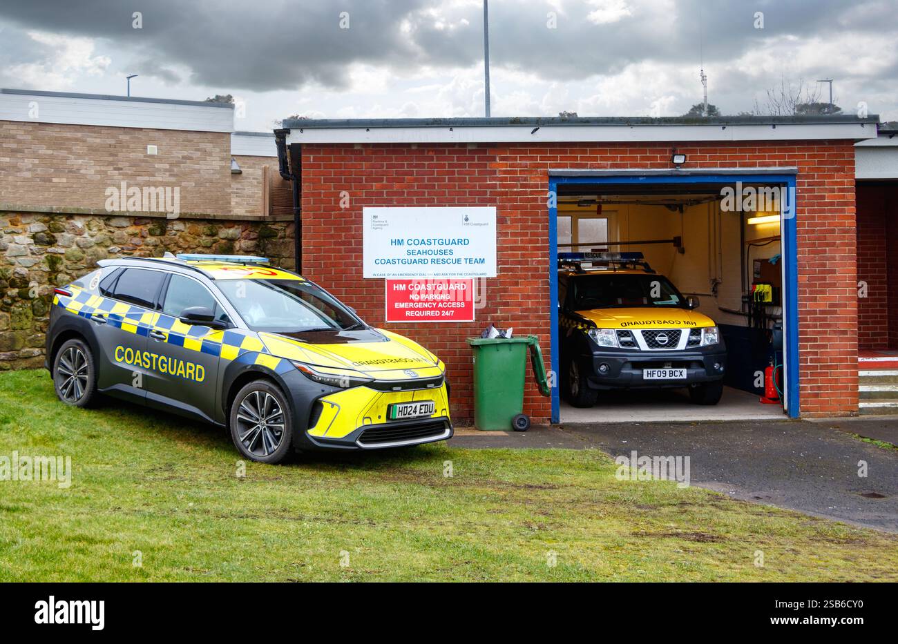 Coastguard vehicles parked at a small brick station, one inside the ...
