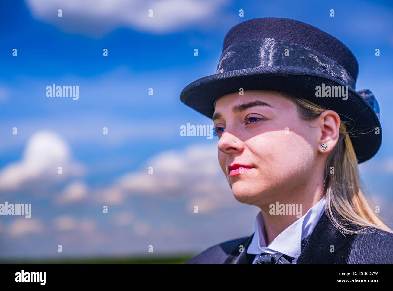 A young pretty lady funeral director in traditional attire with top hat ...