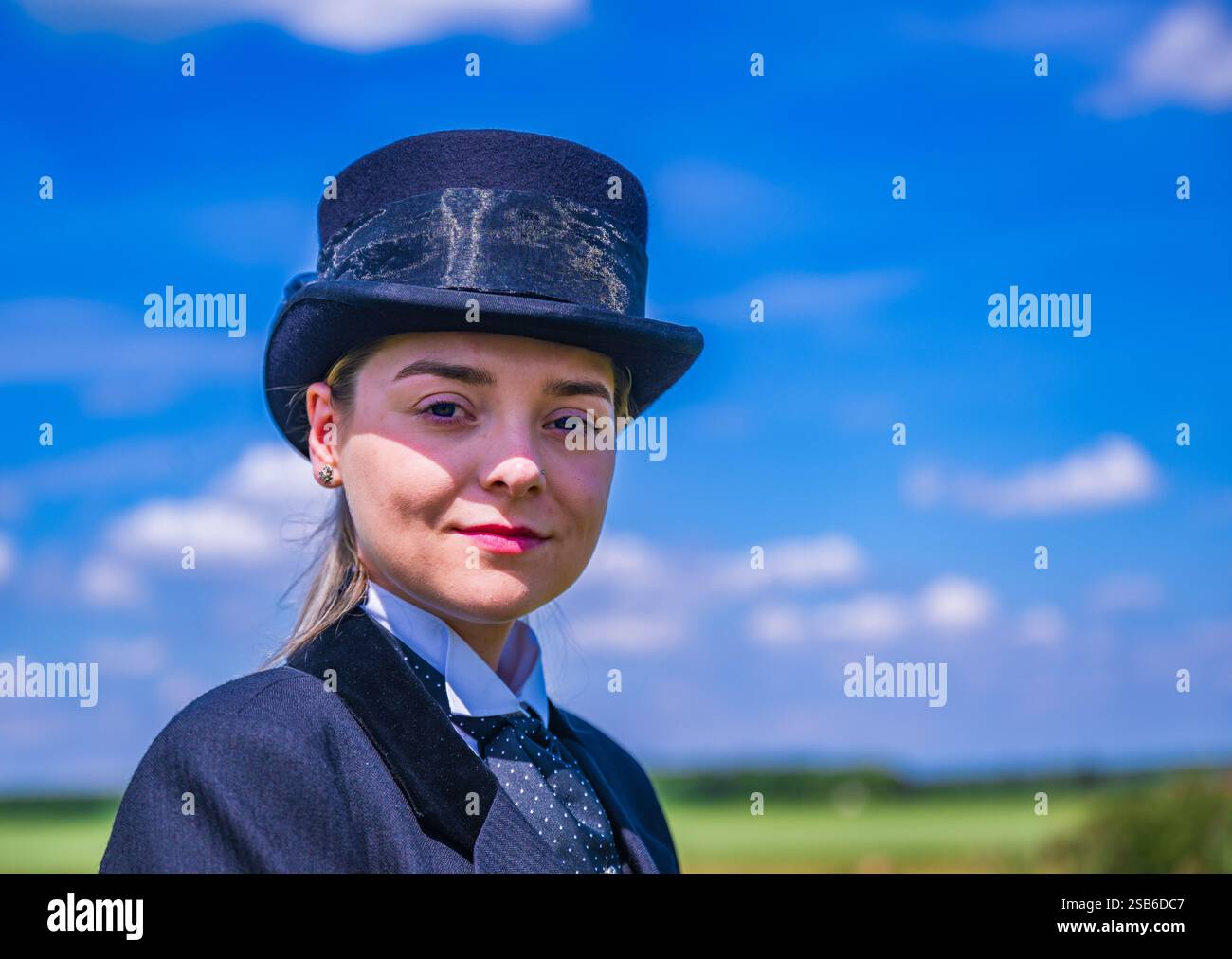 A young pretty lady funeral director in traditional attire with top hat ...