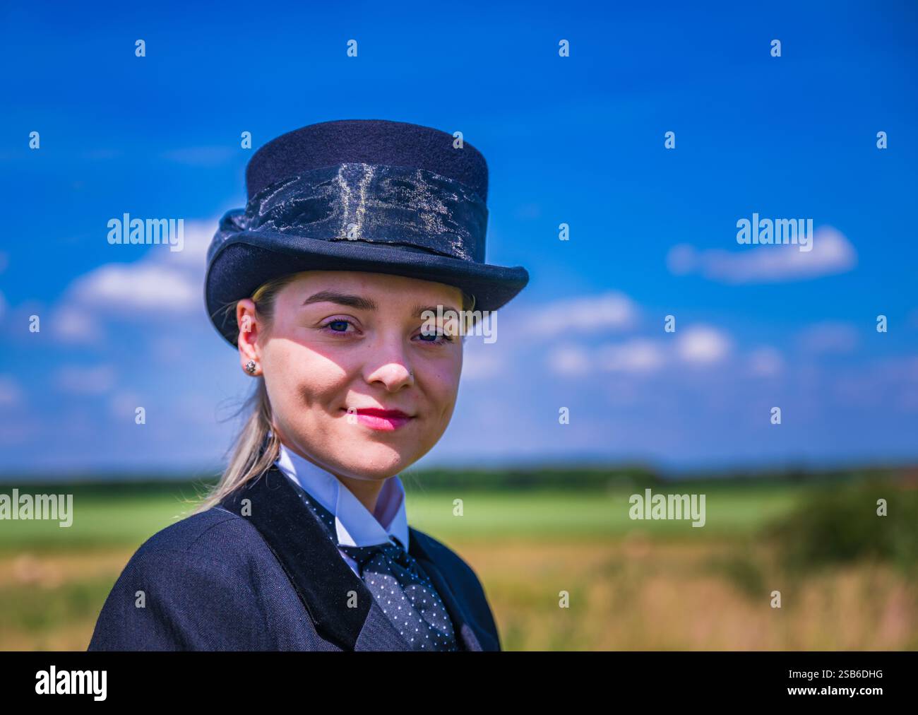 A young pretty lady funeral director in traditional attire with top hat ...