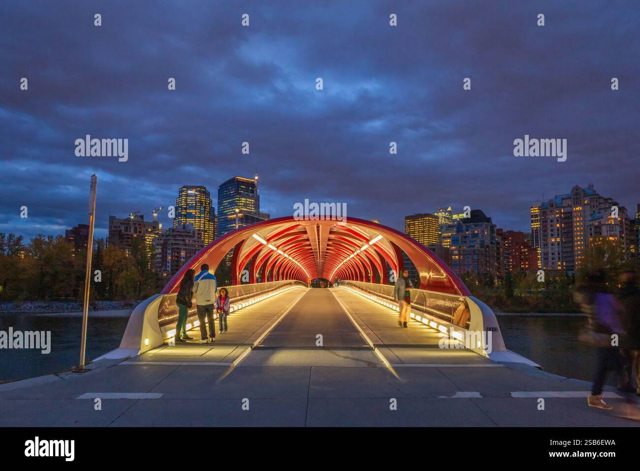 Peace Bridge in Calgary, Canada, illuminated at dusk. The red spiral ...