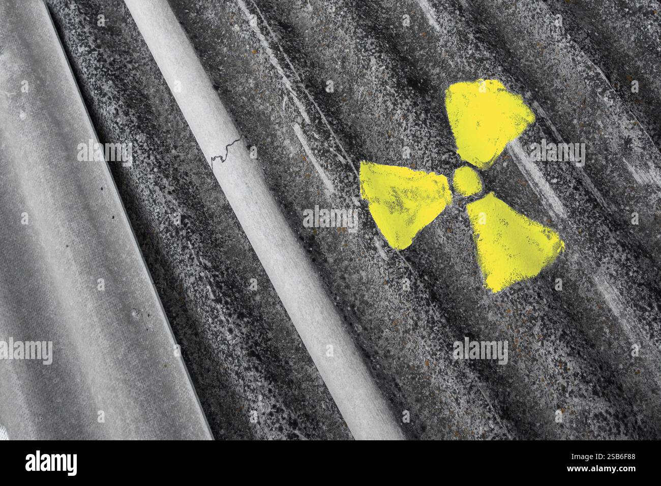 Radioactive symbol smudged with yellow paint on weathered wavy asbestos ...