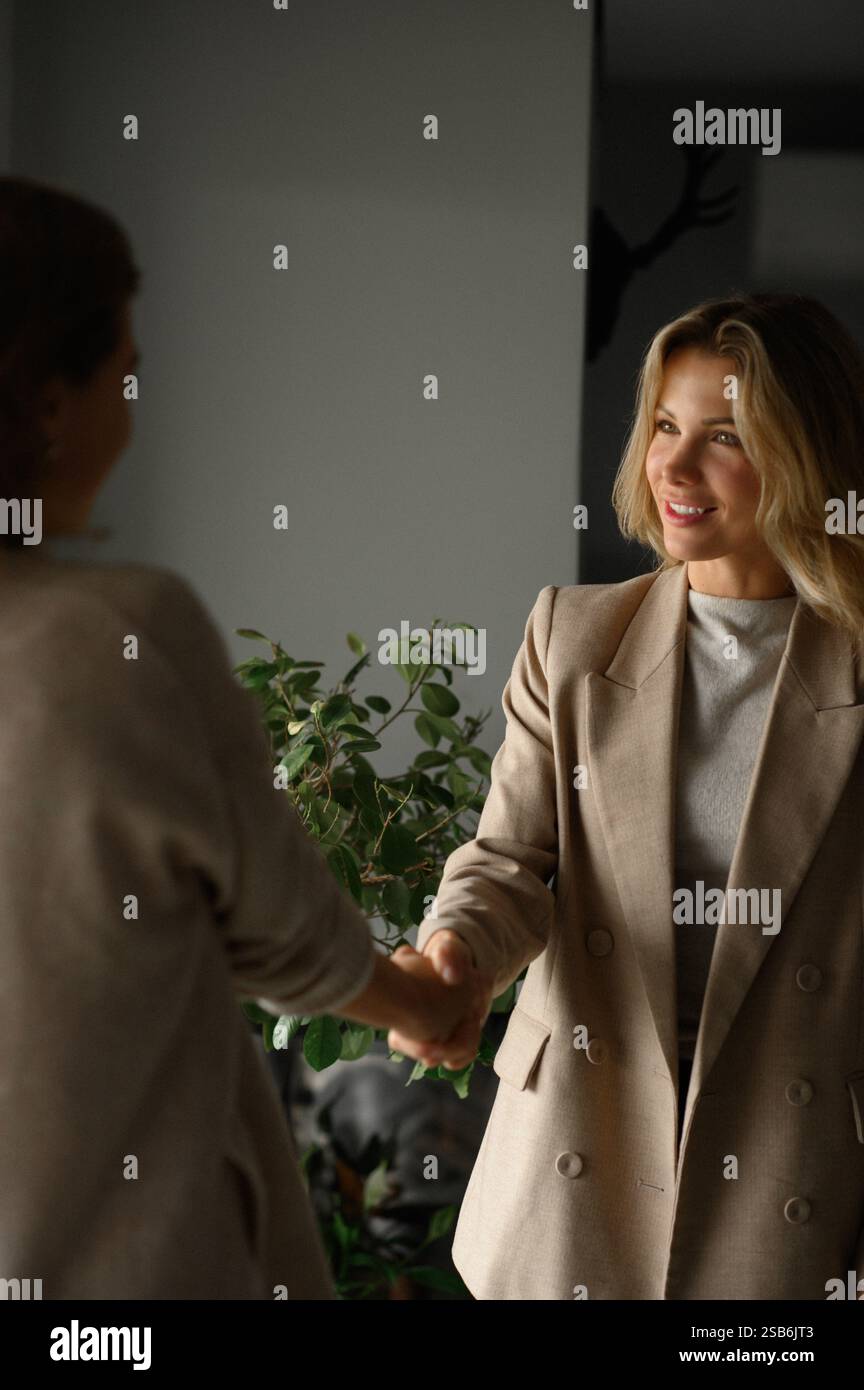 A business lady confidently shakes hands with her colleague in a ...