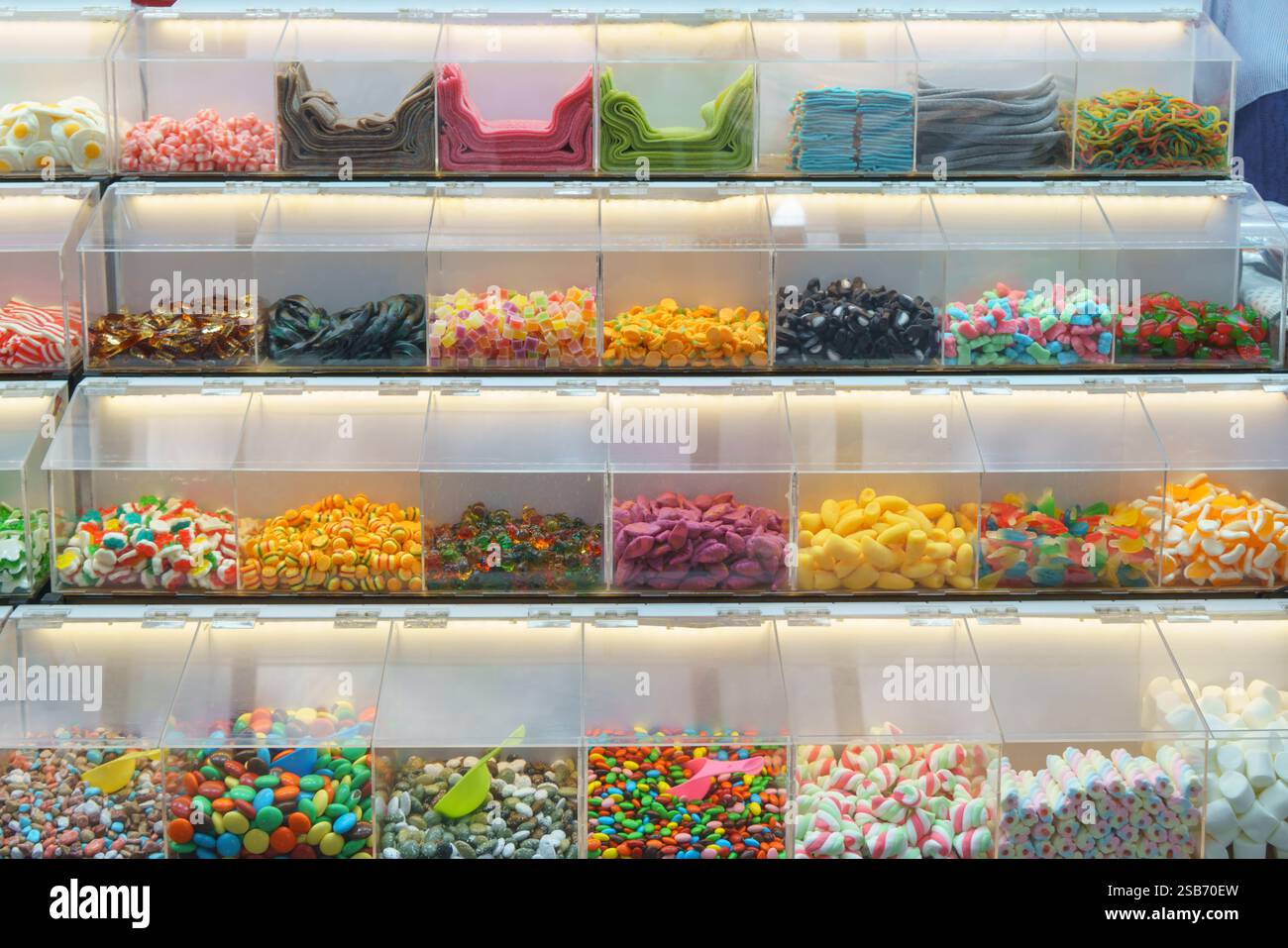 Rows of transparent bins filled with a variety of colorful candies ...