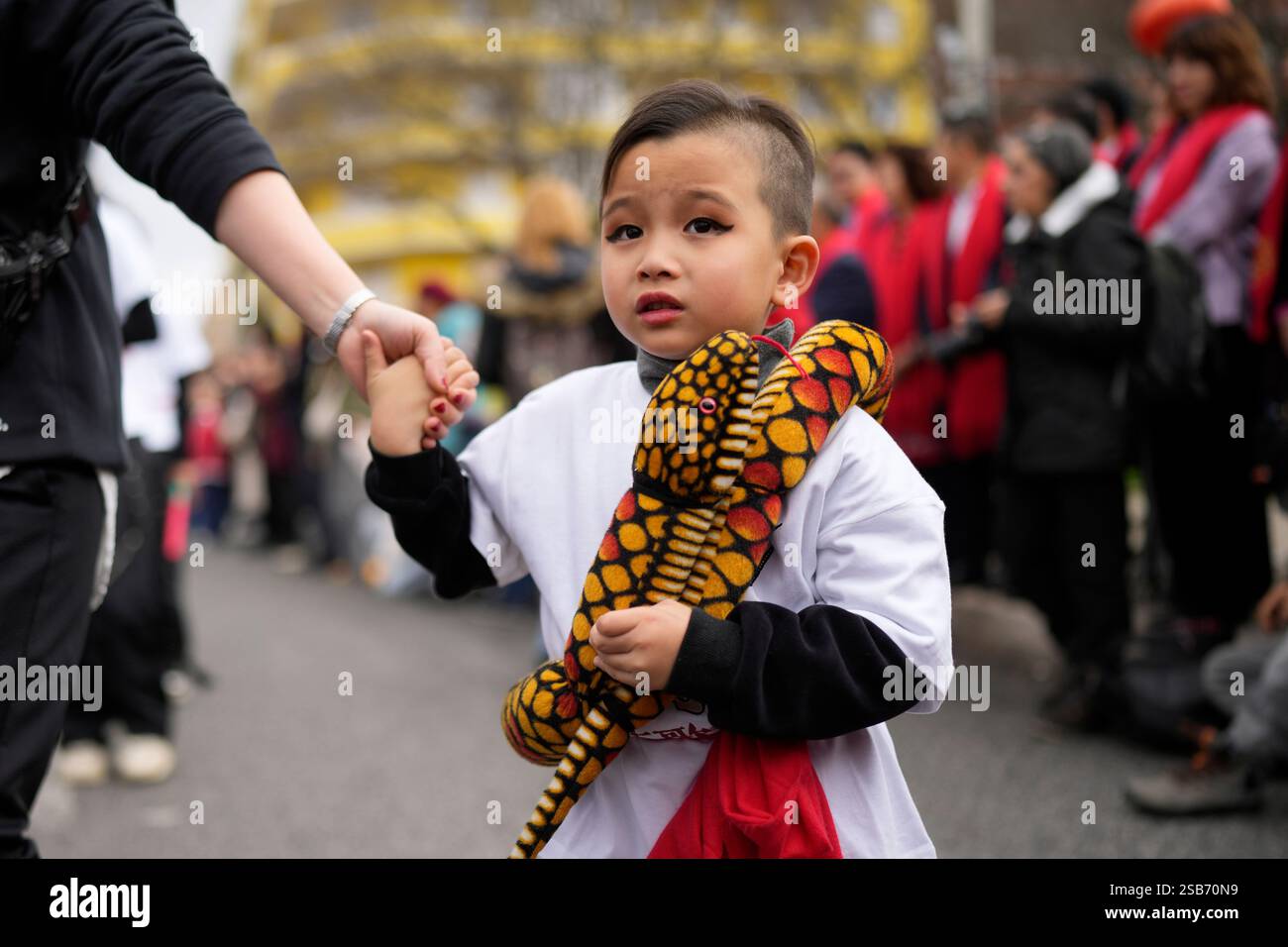 A child carries a stuffed toy snake after taking part in a parade ...